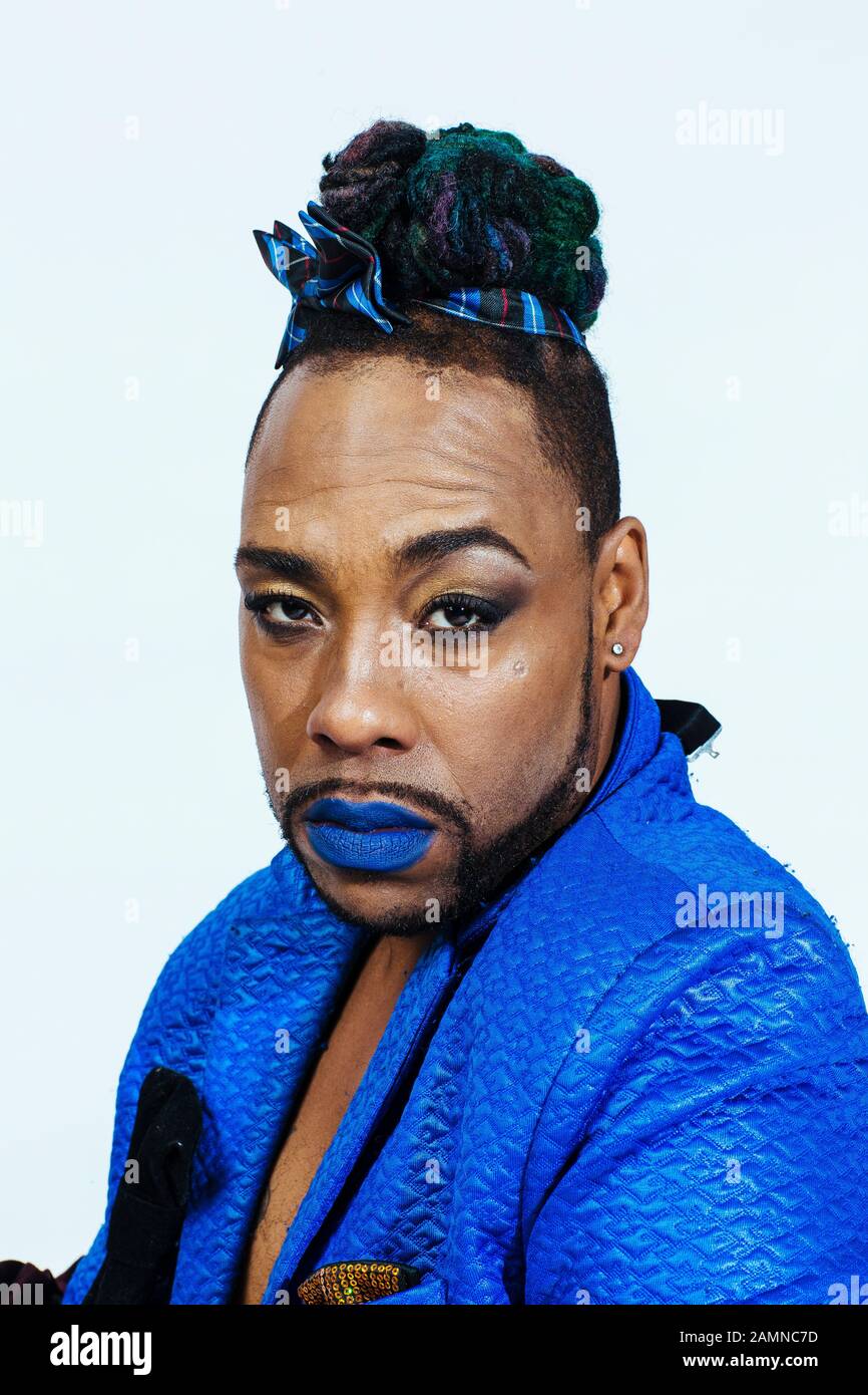 Closeup portrait of a man with blue lips dressing in blue sitting ...