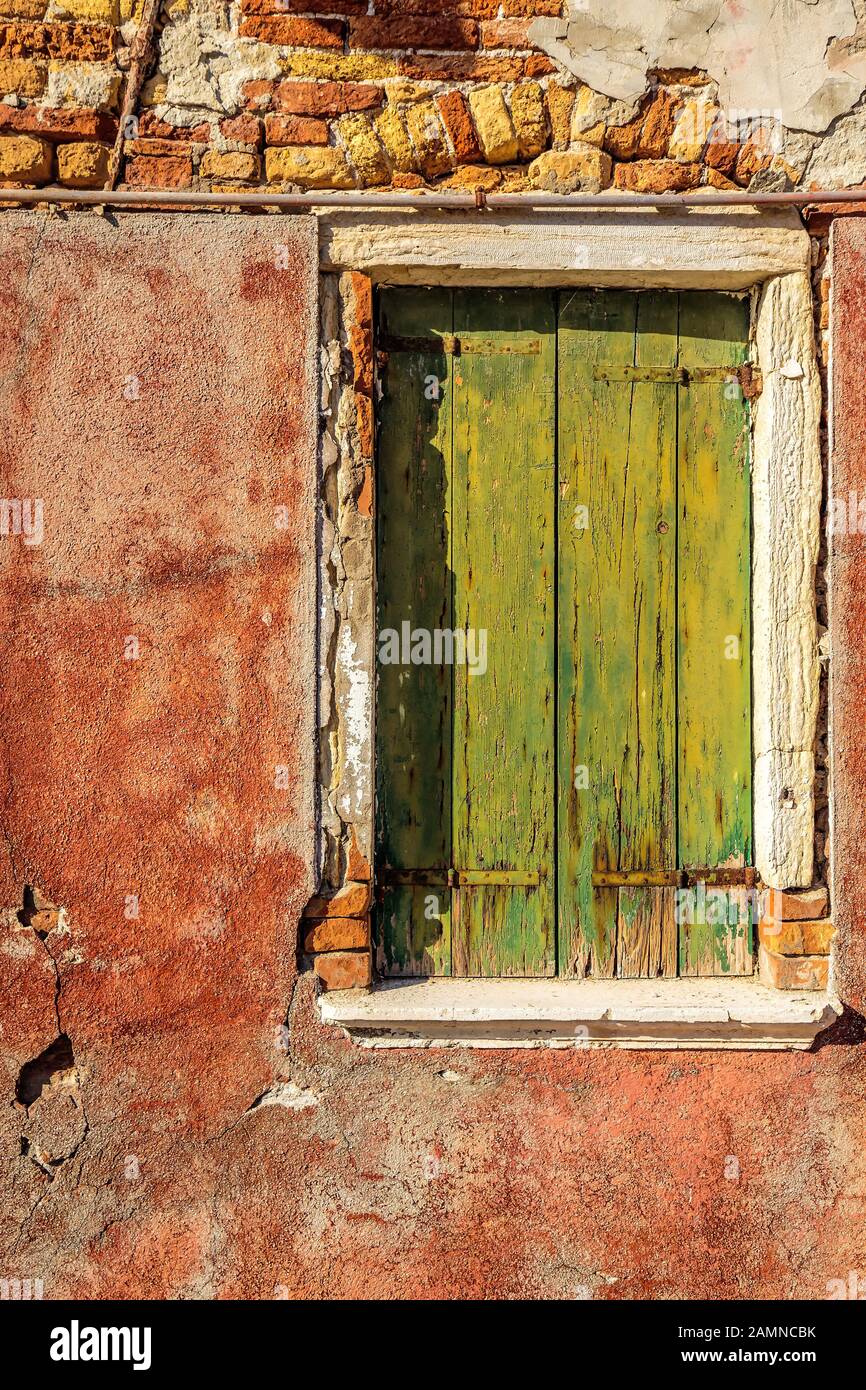 Picturesque window on very old orange wall of houses on the famous ...