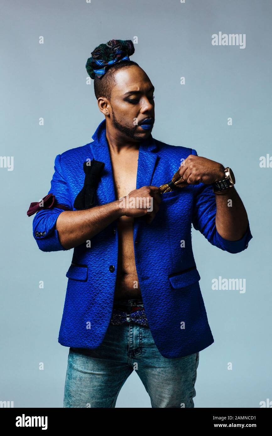 portrait of a man with blue lips dressing in blue sitting . Studio ...