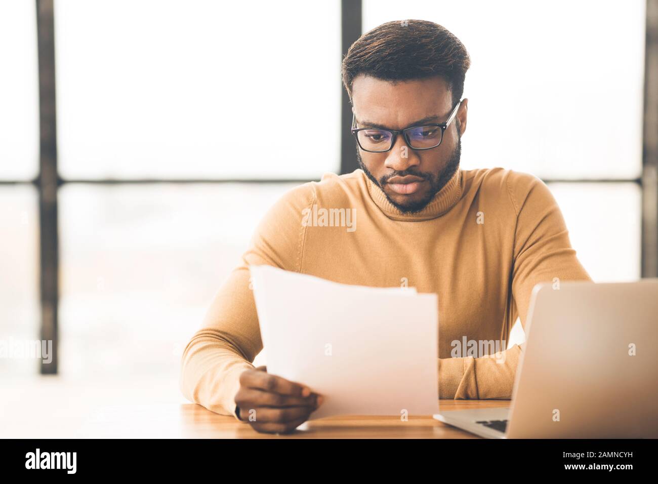 African american manager checking reports in modern office Stock Photo ...