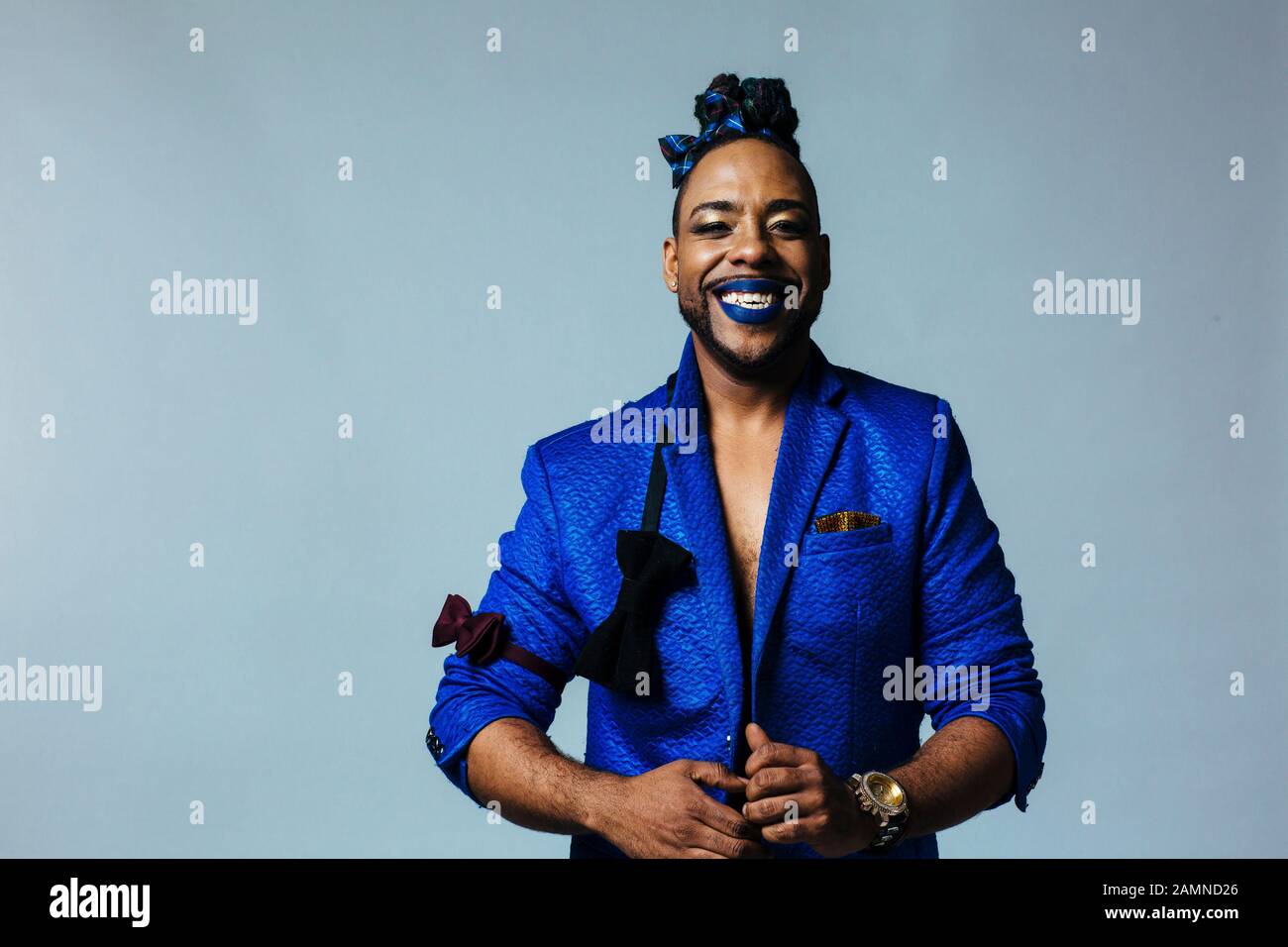 portrait of a man with blue lips dressing in blue sitting . Studio ...