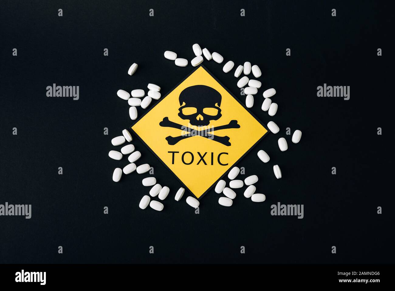 Top view of pills and toxic sign isolated on black Stock Photo - Alamy
