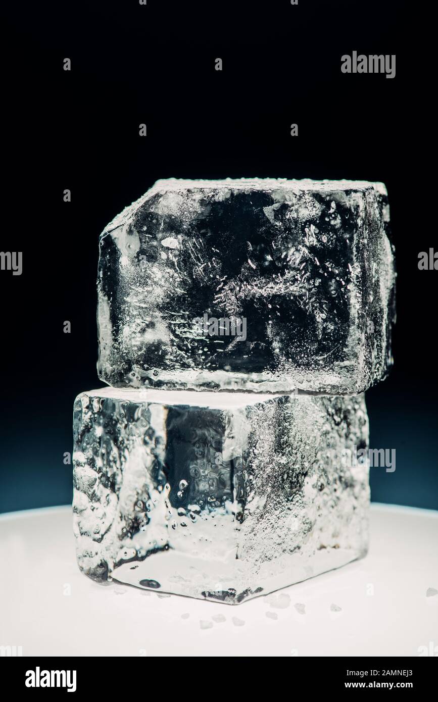 close up view of square ice cubes on illuminated circle isolated on ...