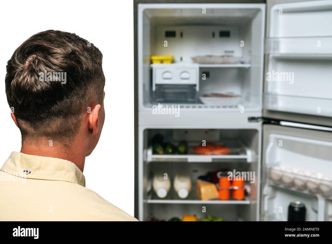 guy looking at open fridge with food isolated on white Stock Photo - Alamy