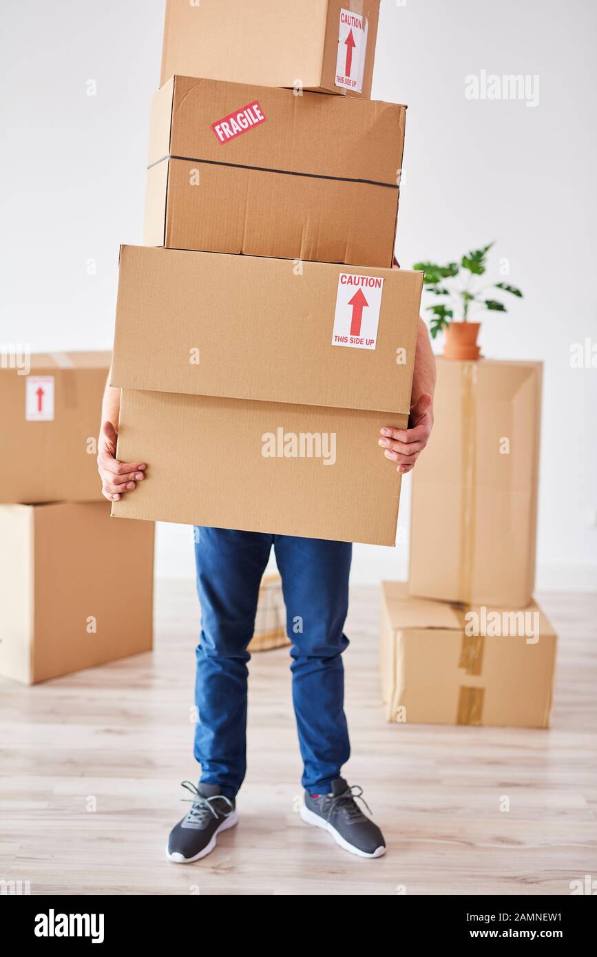 Man holding stack of boxes in front of his face Stock Photo - Alamy