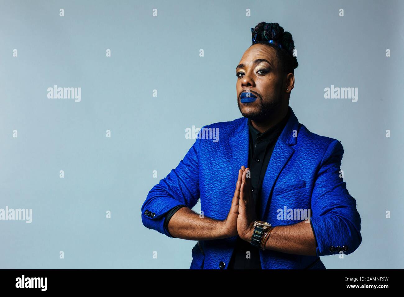 portrait of a man with blue lips dressing in blue sitting . Studio ...