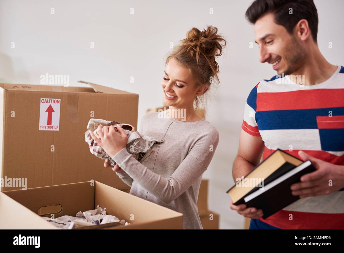 Happy couple packing their stuff into boxes Stock Photo - Alamy