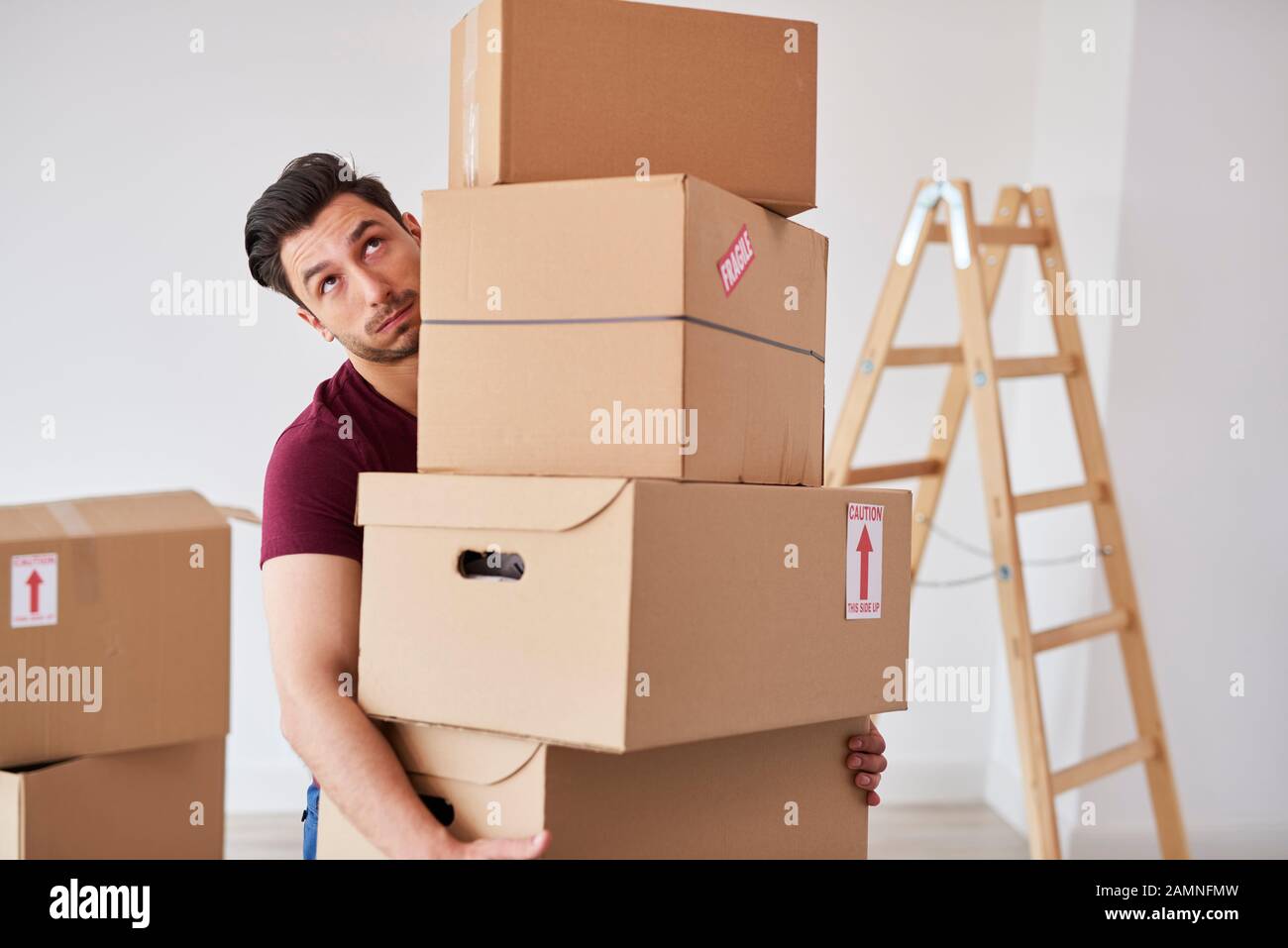 Man carrying stack of heavy cardboard boxes Stock Photo - Alamy