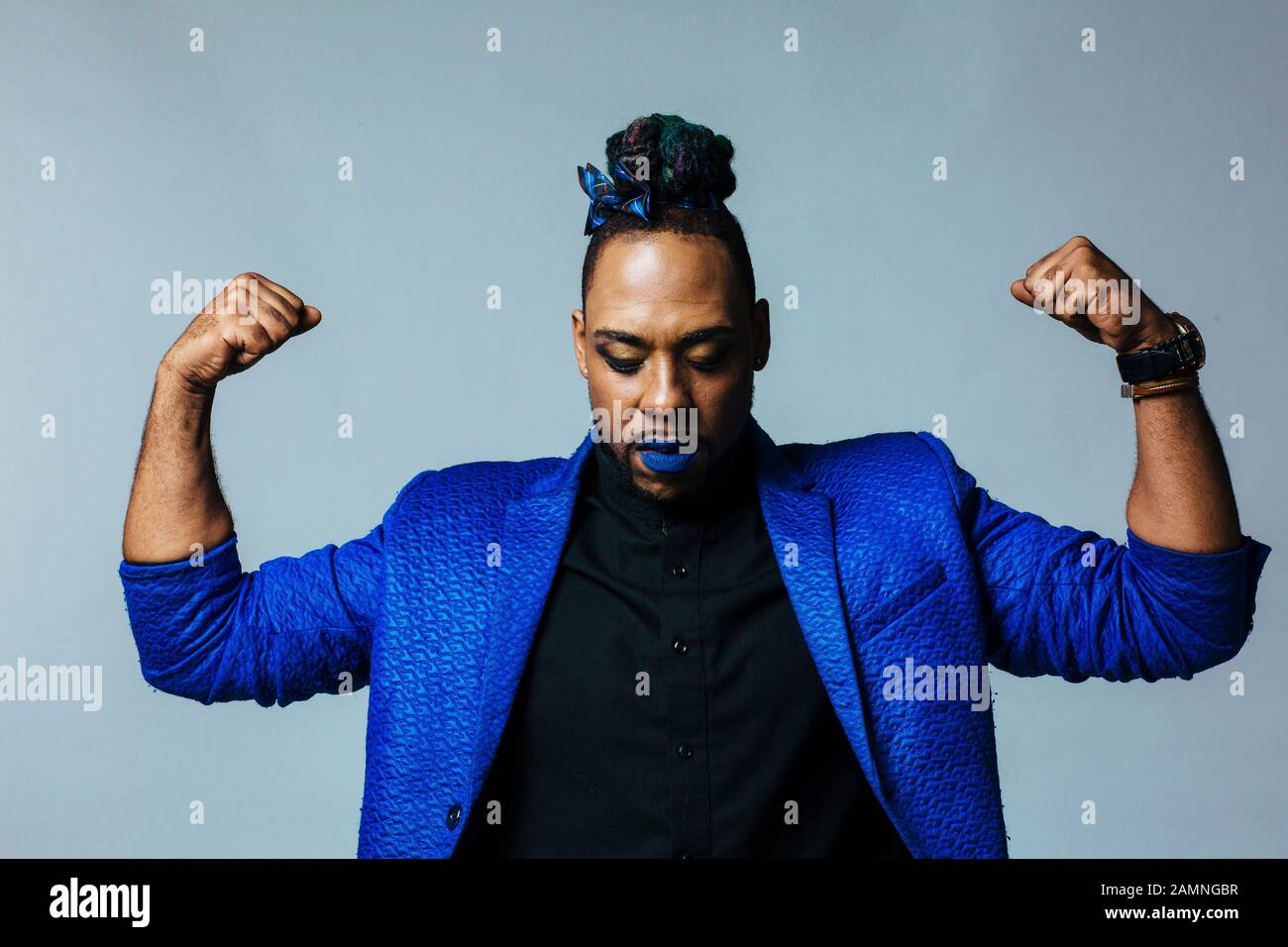 portrait of a man with blue lips dressing in blue sitting . Studio ...