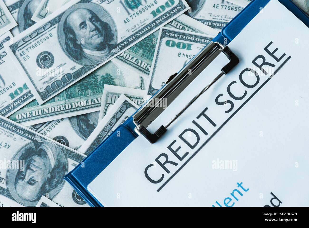 top view of clipboard with credit score lettering on dollar banknotes ...