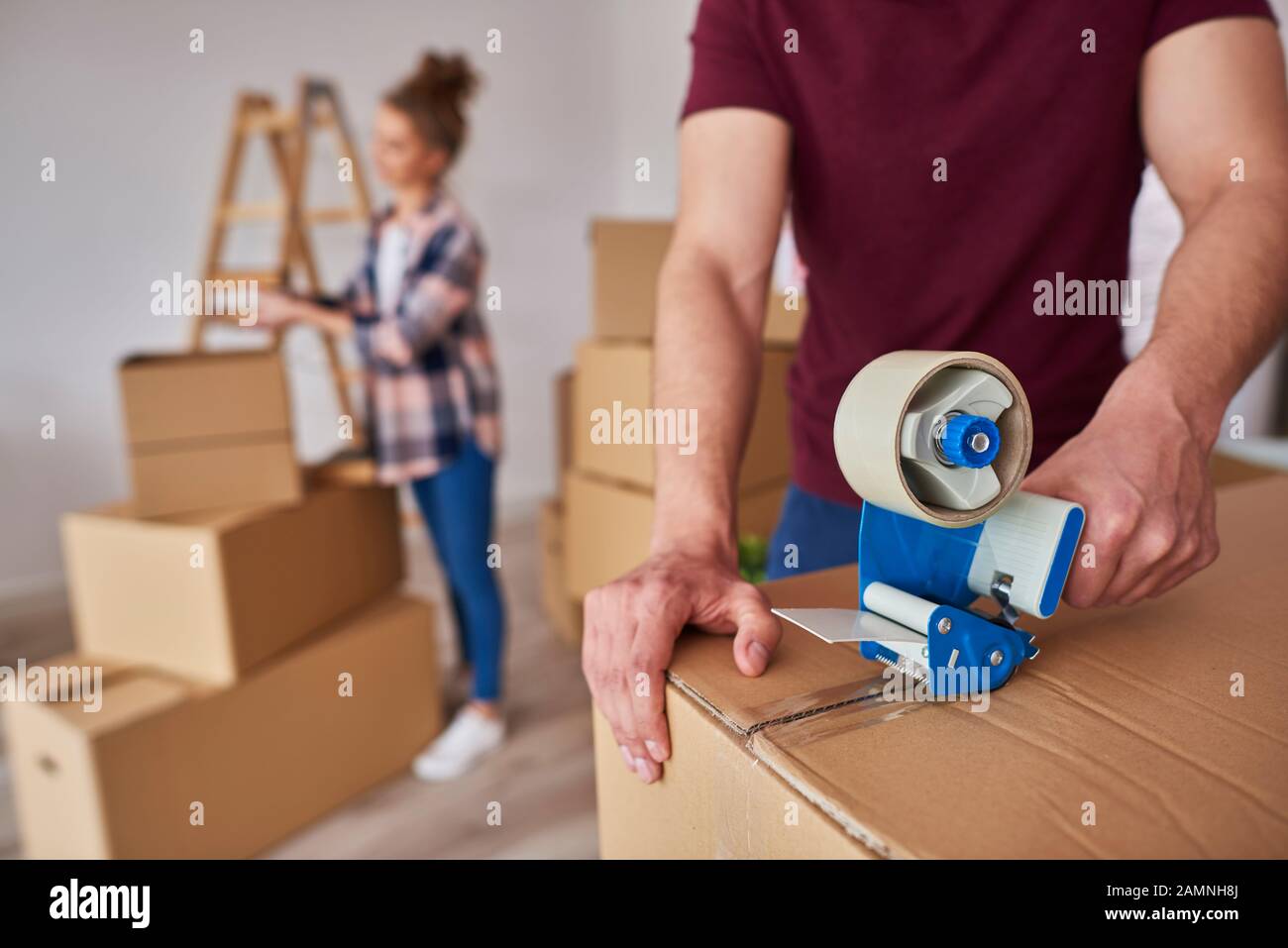 Man with adhesive tape packing boxes Stock Photo - Alamy