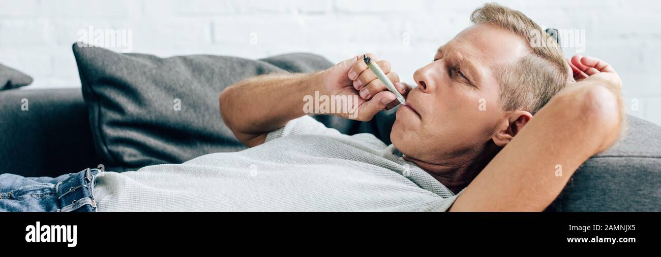 panoramic shot of man smoking blunt with medical cannabis Stock Photo ...