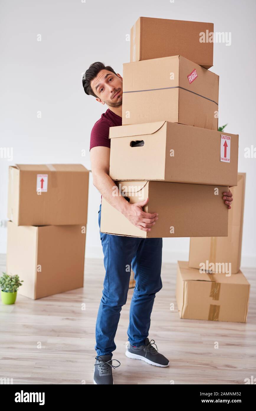 Portrait of man carrying stack of heavy cardboard boxes Stock Photo - Alamy