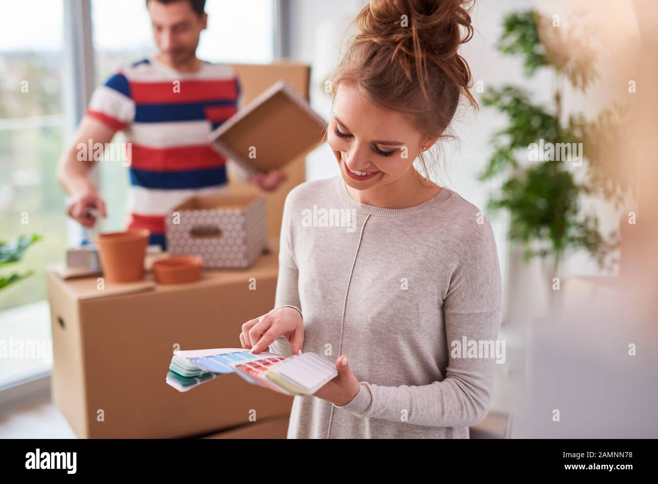 Smiling woman choosing the perfect color from color swatch Stock Photo ...