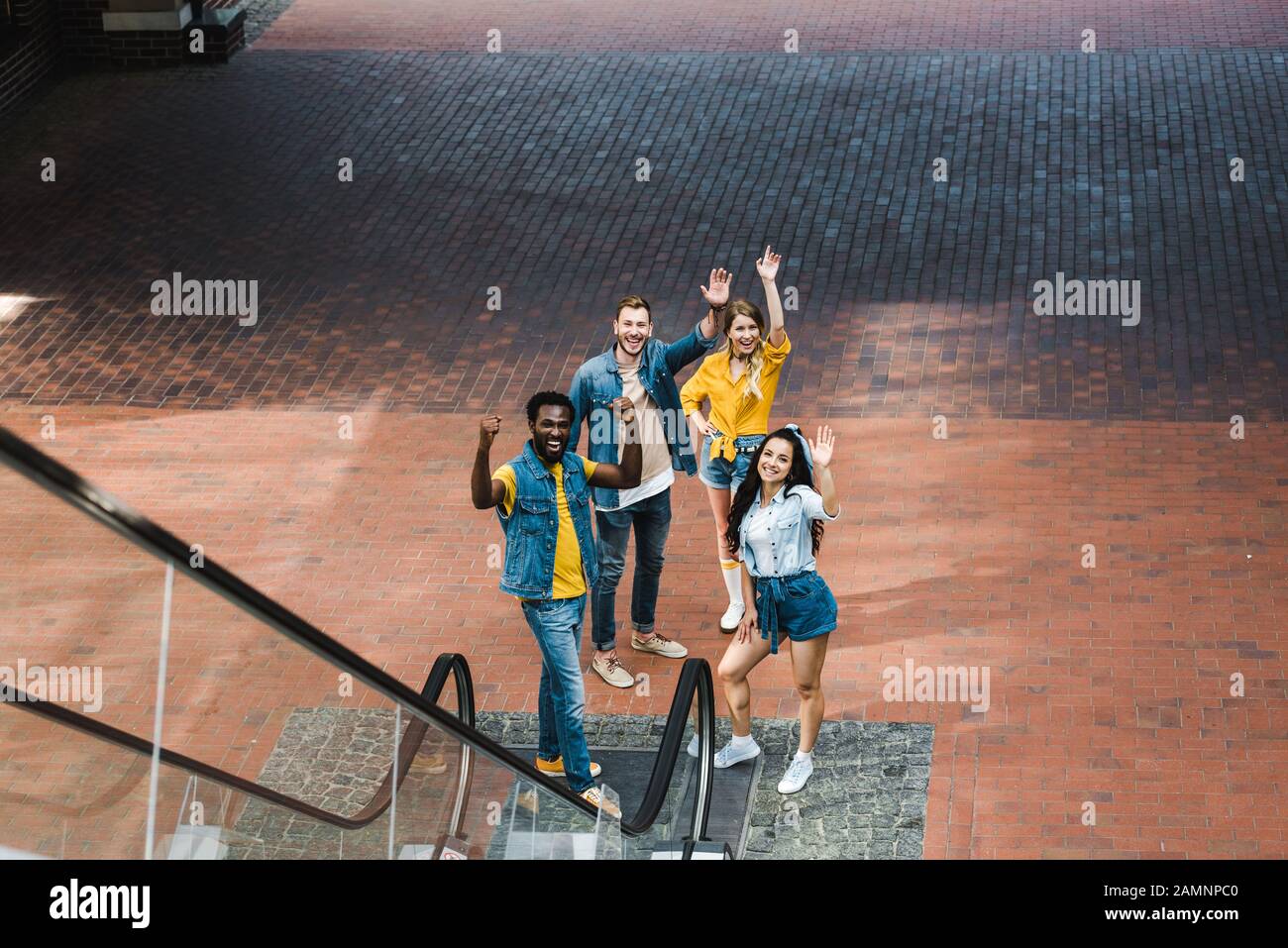 happy multicultural group of friends gesturing while standing together ...