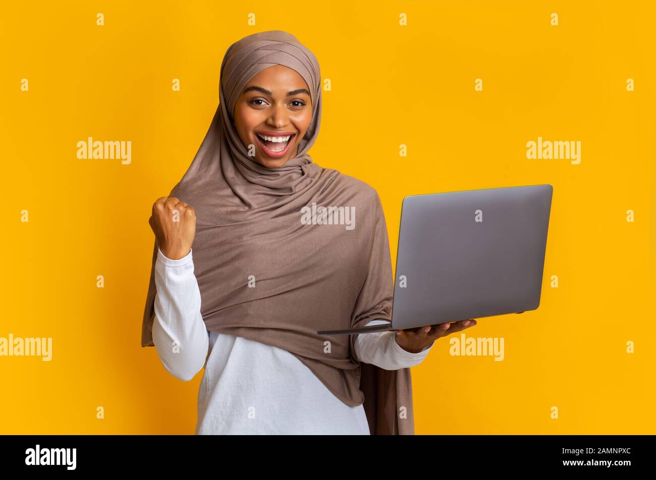Cheerful Afro Muslim Girl In Headscarf Rejoicing Success With Laptop ...