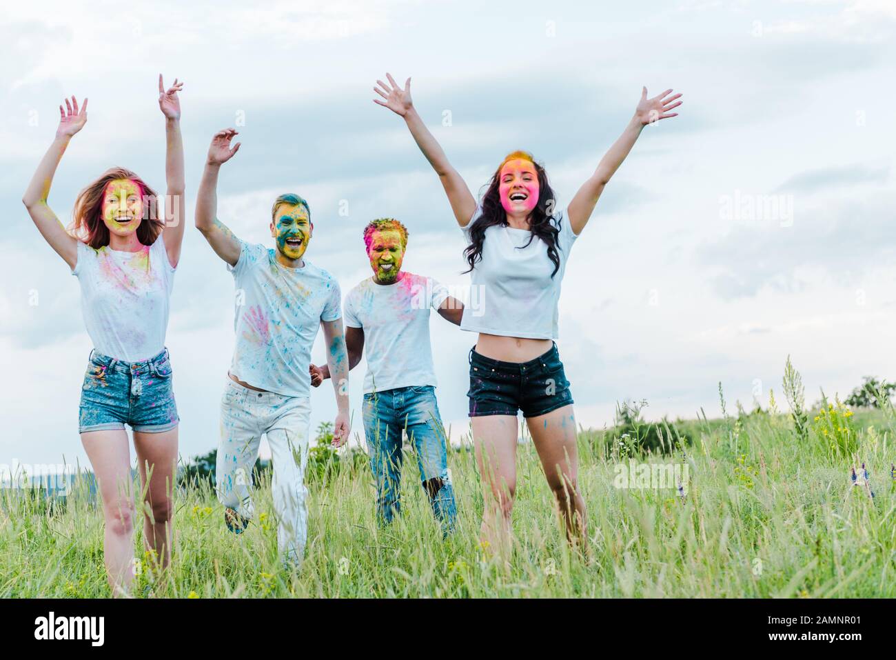 happy multicultural friends with colorful holi paints on faces ...