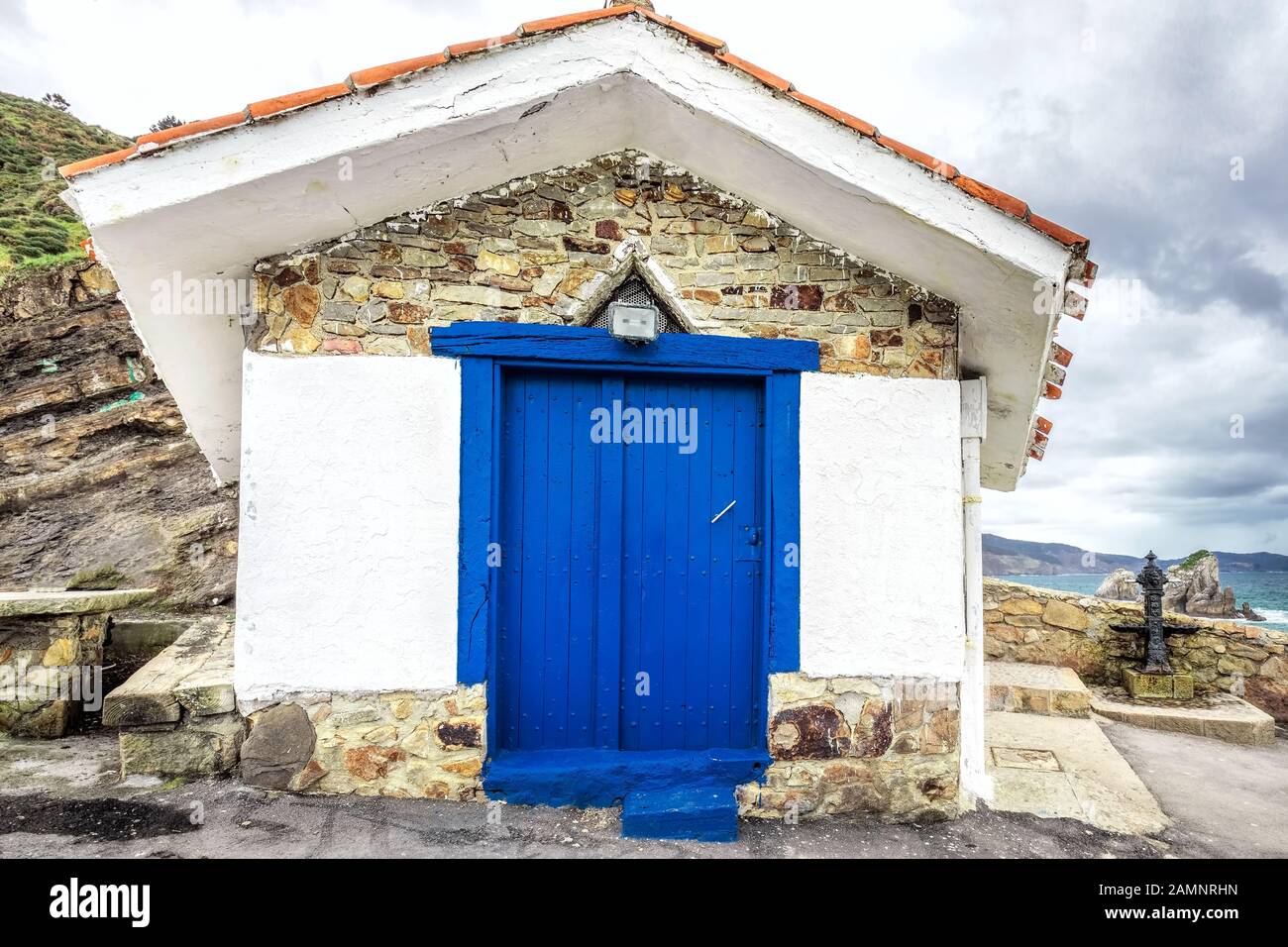 Boat house with blue door and red roof at San Juan de Gaztelugatxe ...