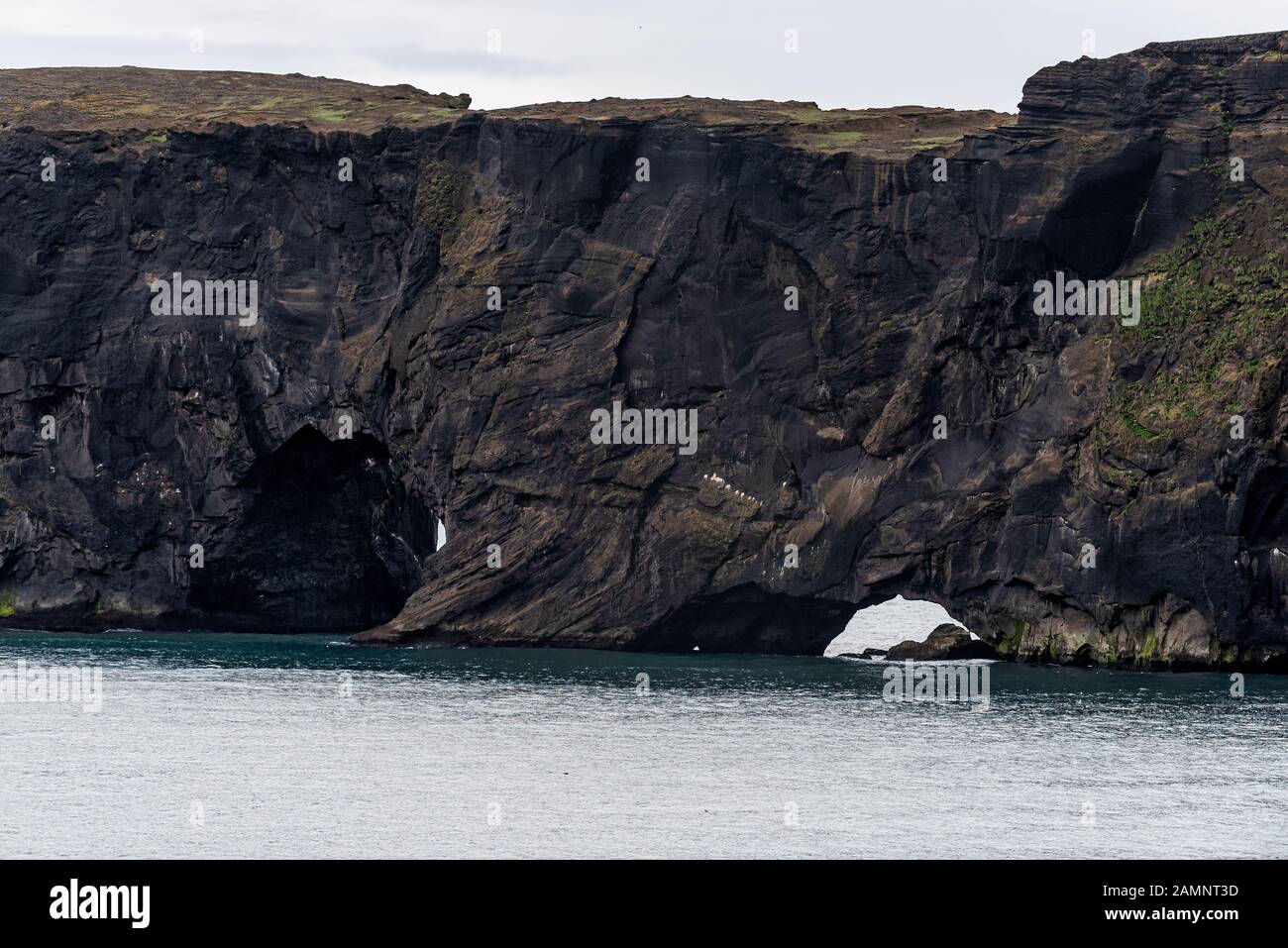 Vik, Iceland with closeup of rock formation arch at Dyrholaey ...