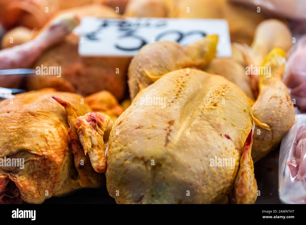 Raw whole chickens with uncooked skin in butcher shop grocery store ...