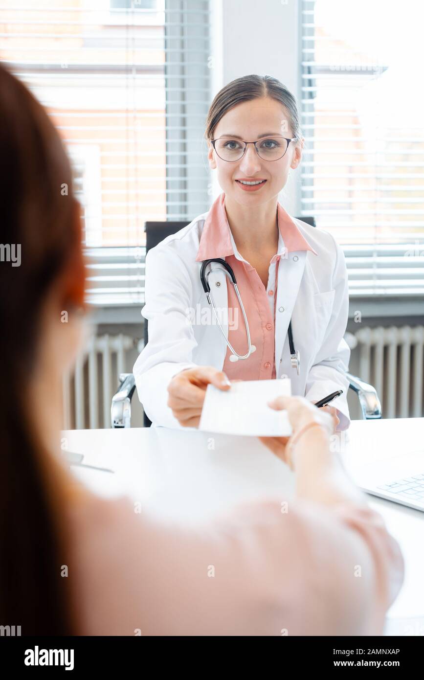 Doctor handing slip for prescription drug over to patient Stock Photo ...