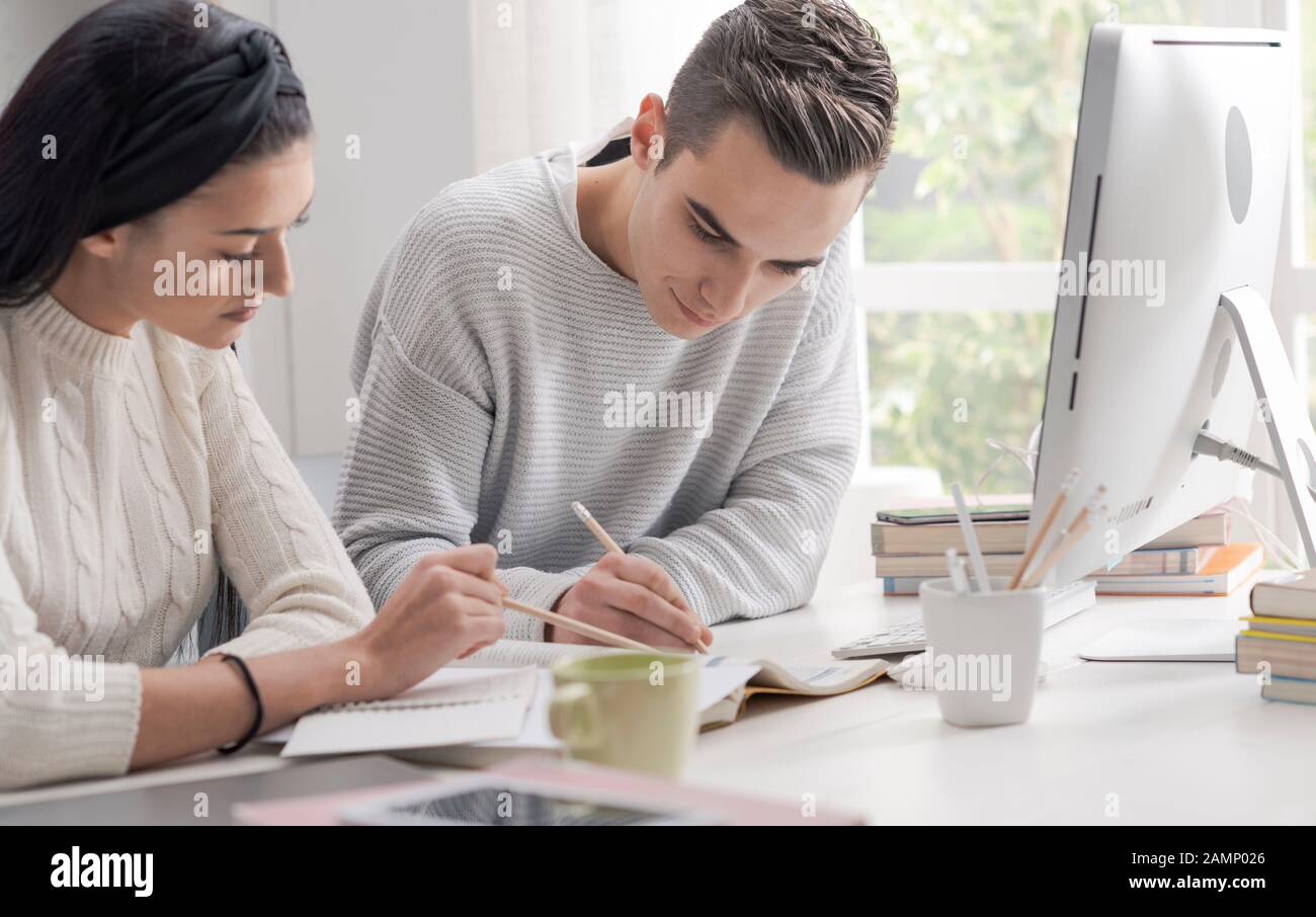 Happy college students in the library, they are studying together ...