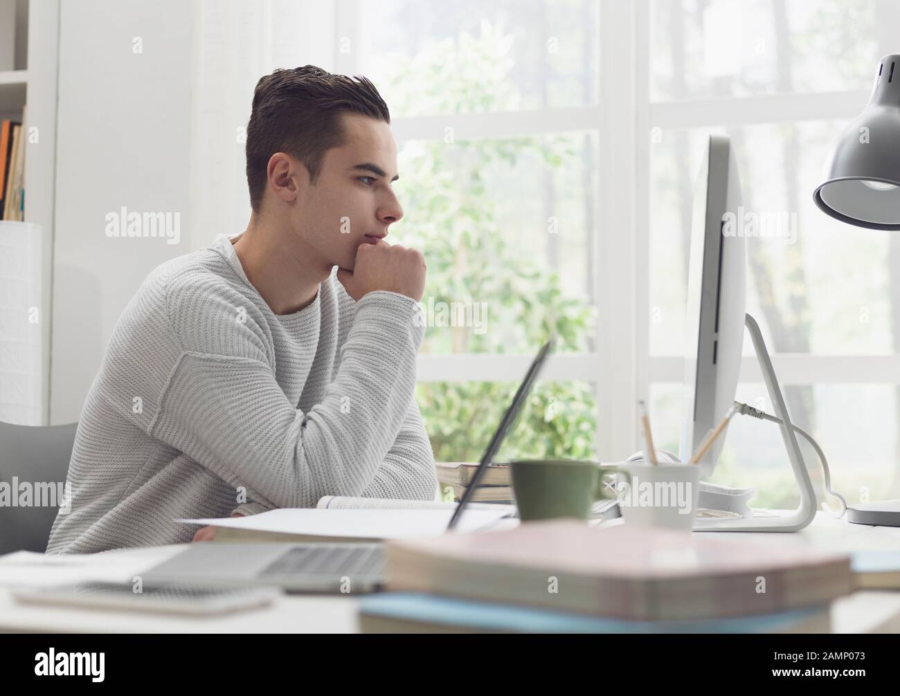 Smart college student using computer at home, he is studying and ...