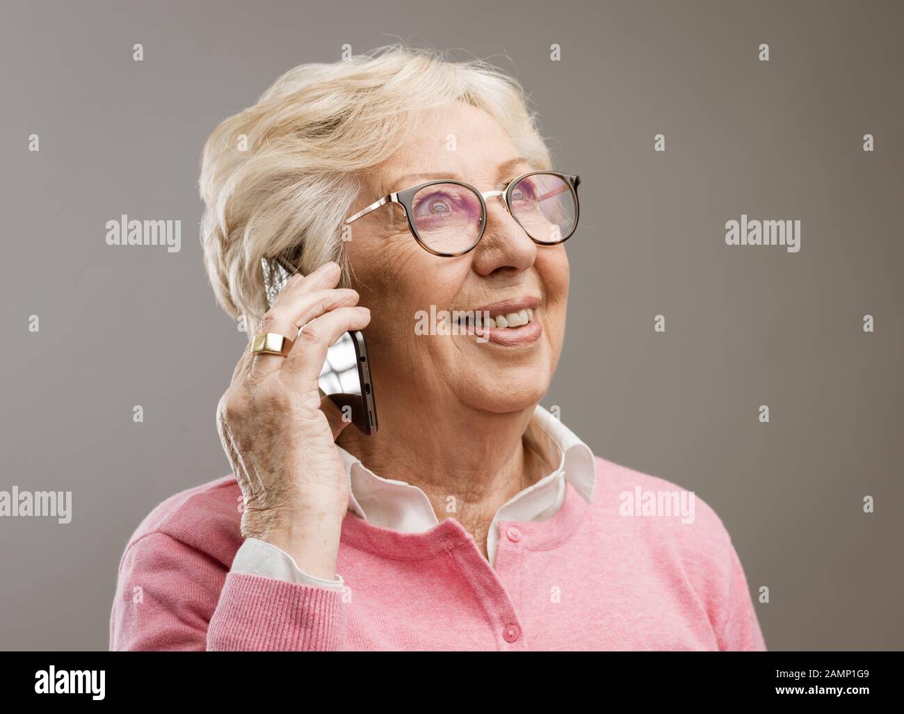 Modern happy senior lady having a phone call on her smartphone and ...