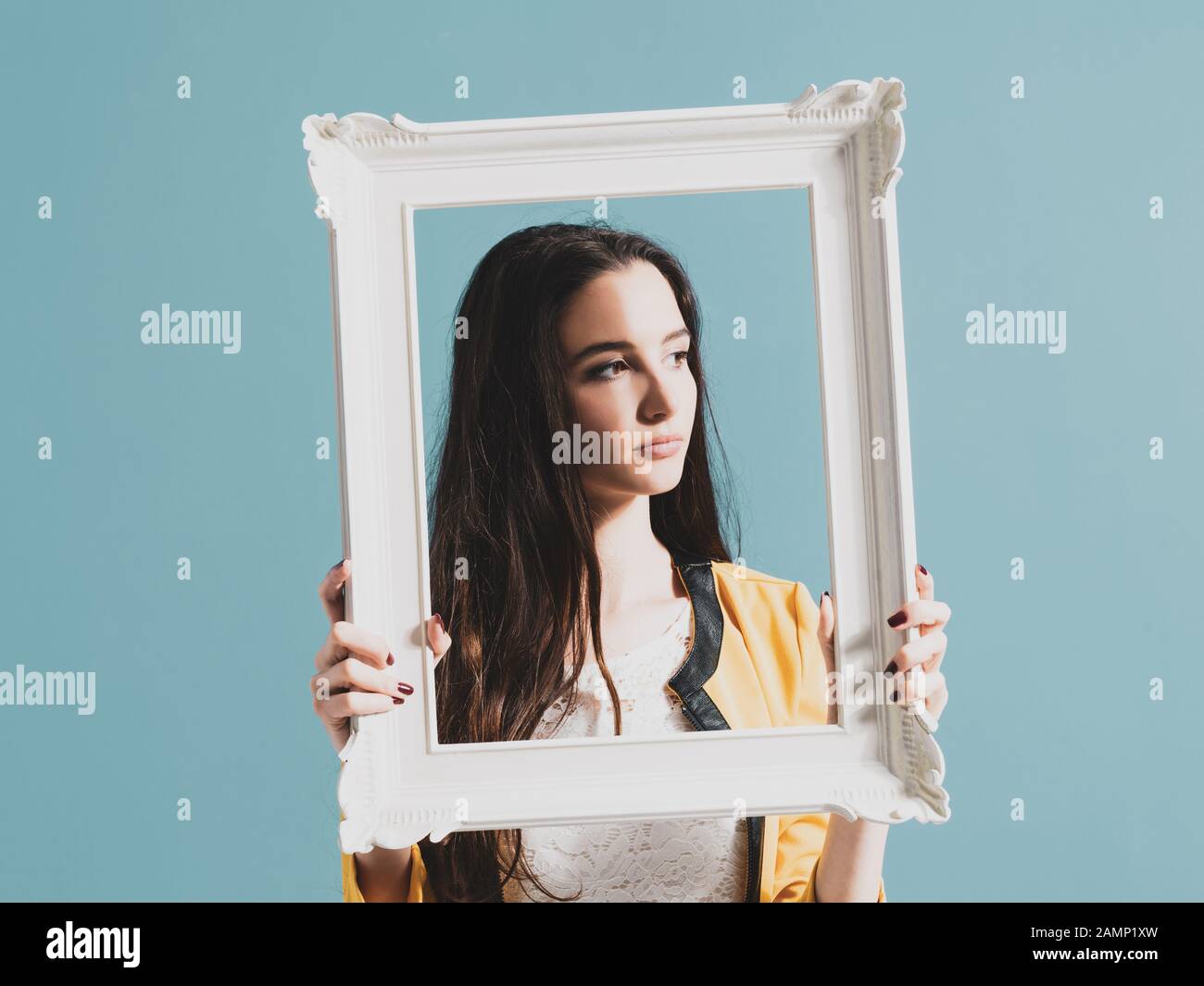 Beautiful woman posing and holding a frame, she looks like a painting ...
