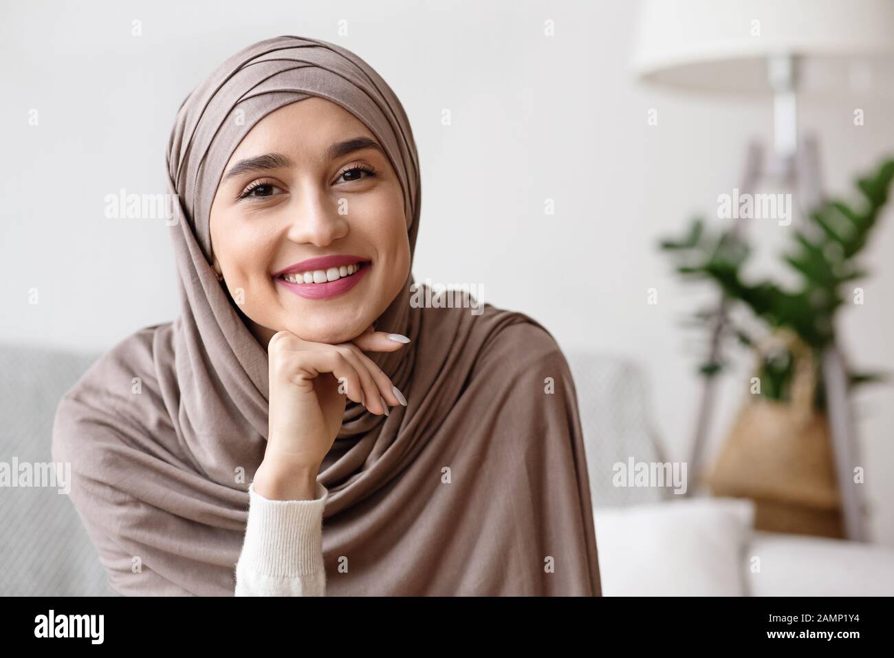 Portrait of smiling muslim girl in hijab resting head on hand Stock ...