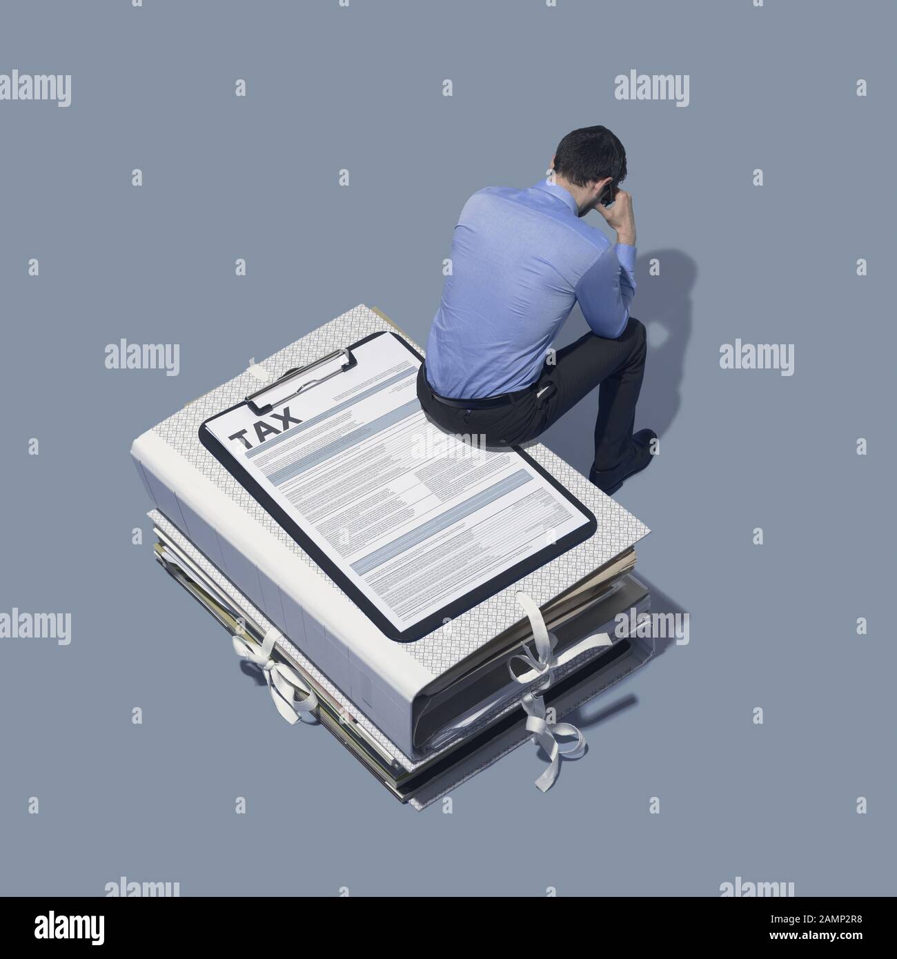 Stressed businessman sitting on a tax form and a pile of paperwork ...