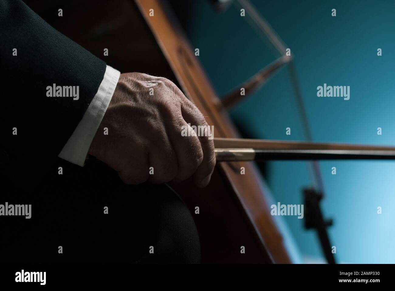 Professional cellist performing on stage, hand close up, classical ...