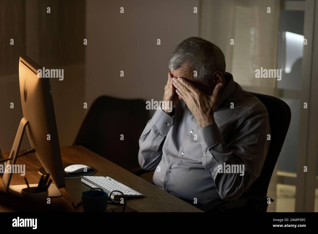 Lonely sad senior man connecting at night with his computer: he is ...