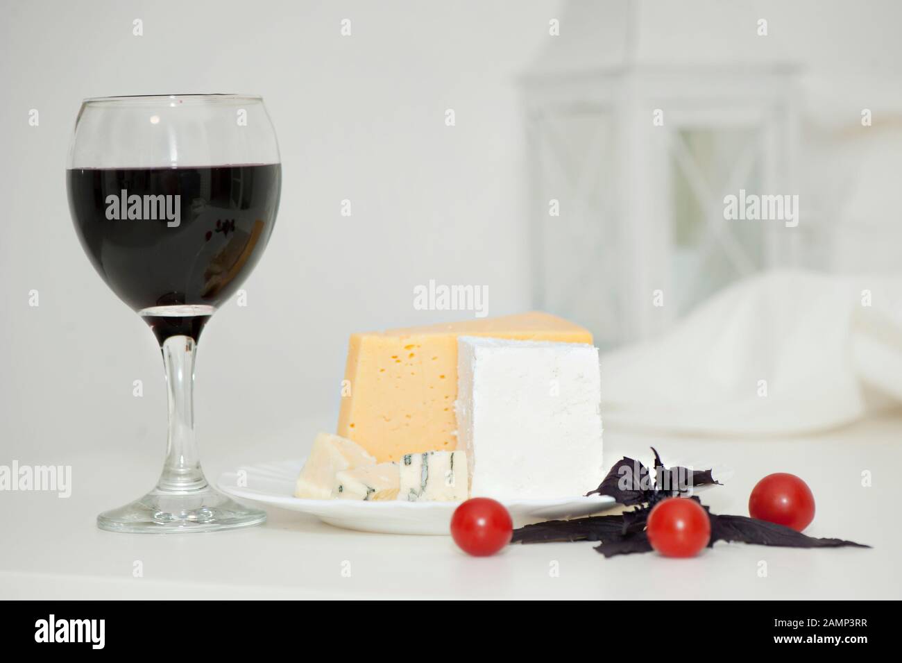 Glass with red wine and cheese on a plate on a light background Stock ...