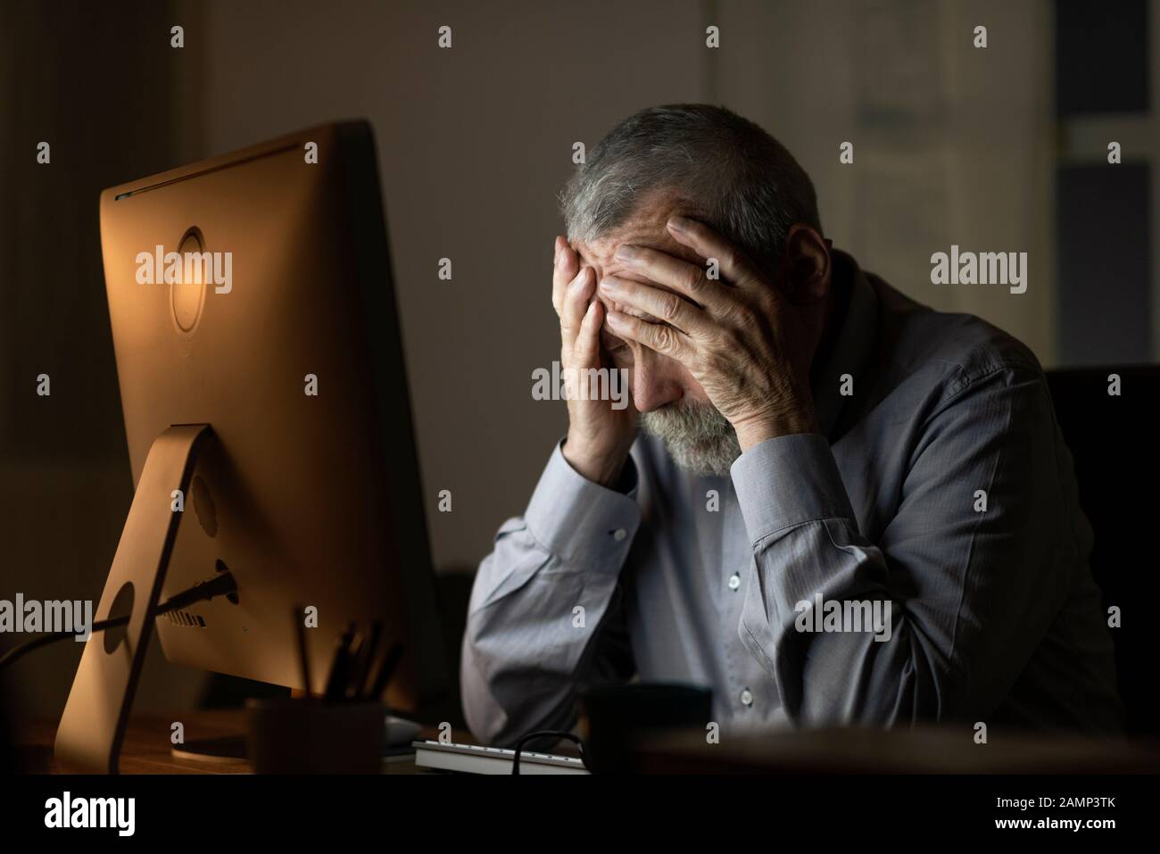 Lonely sad senior man connecting at night with his computer: he is ...