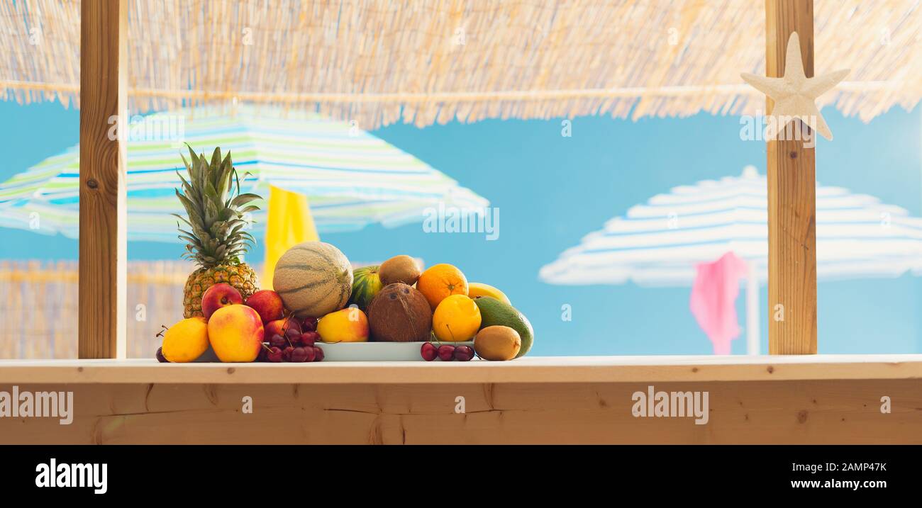 Beach bar kiosk with delicious fresh fruit on the counter and colorful ...