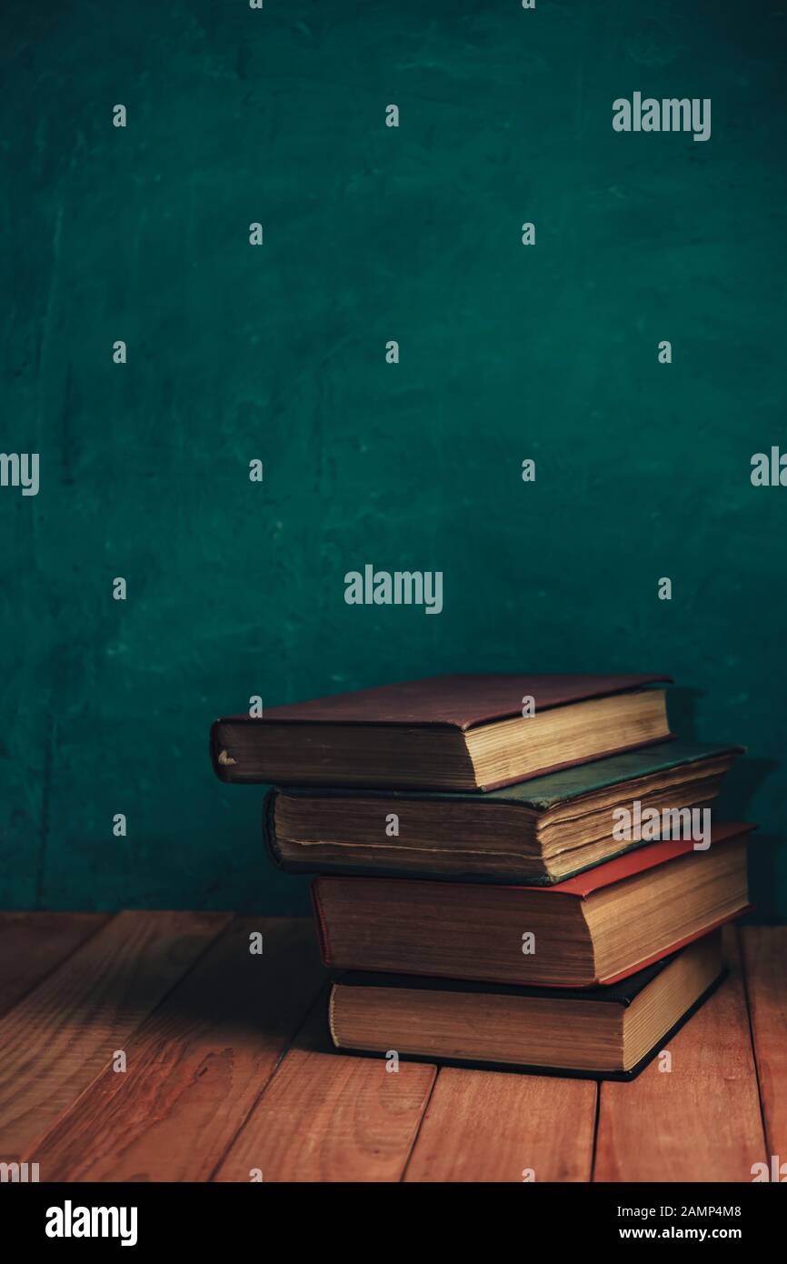 Beautiful old books on a red wooden table. Green wall background Stock ...