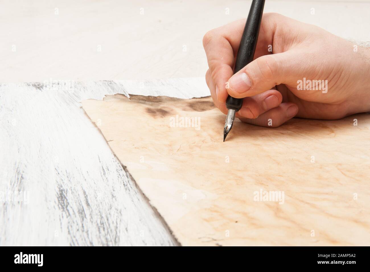 Male hand with pen writes on old paper Stock Photo - Alamy