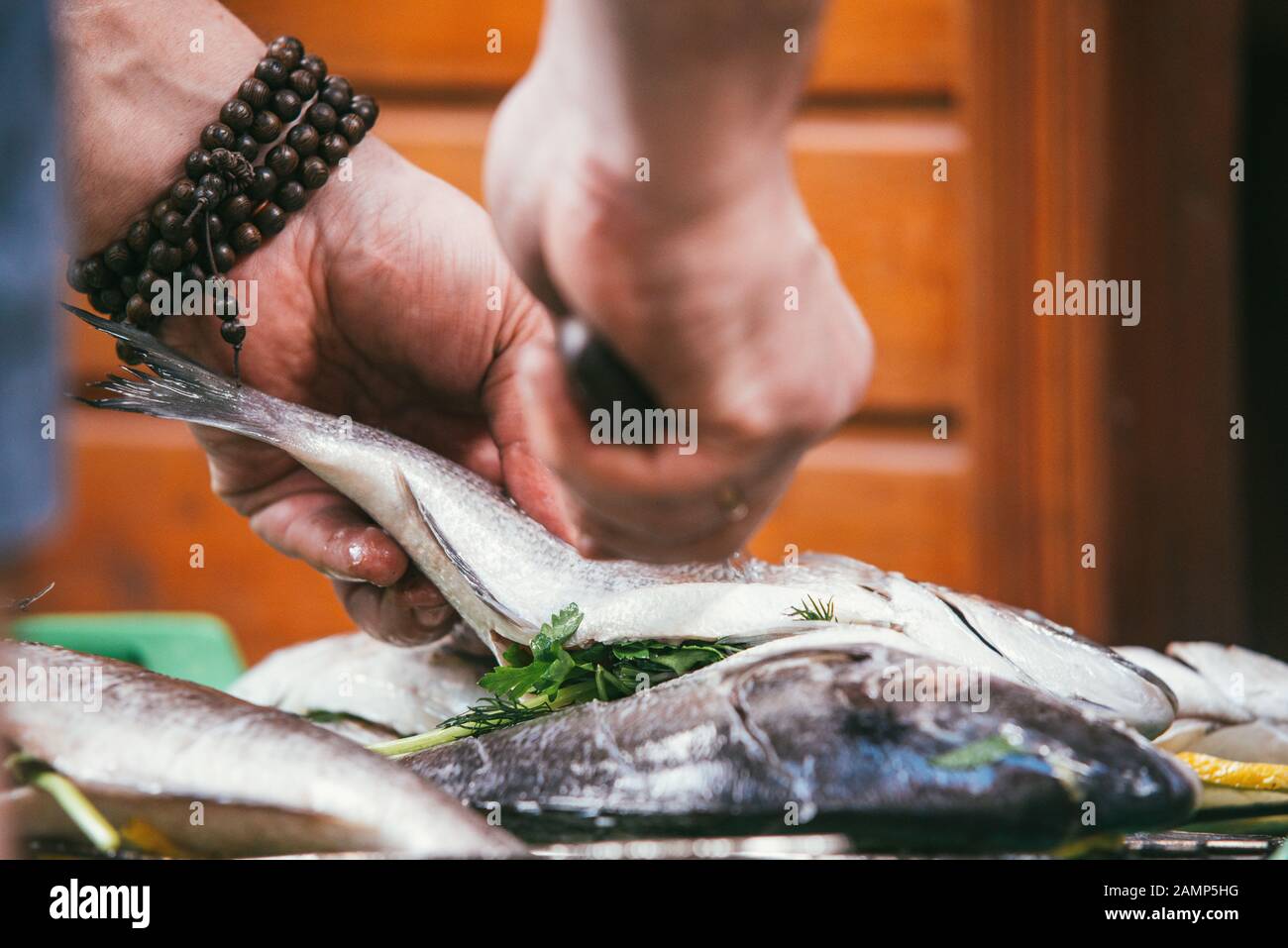the man stuffed fresh and raw fish. With lemon and parsley on a ...