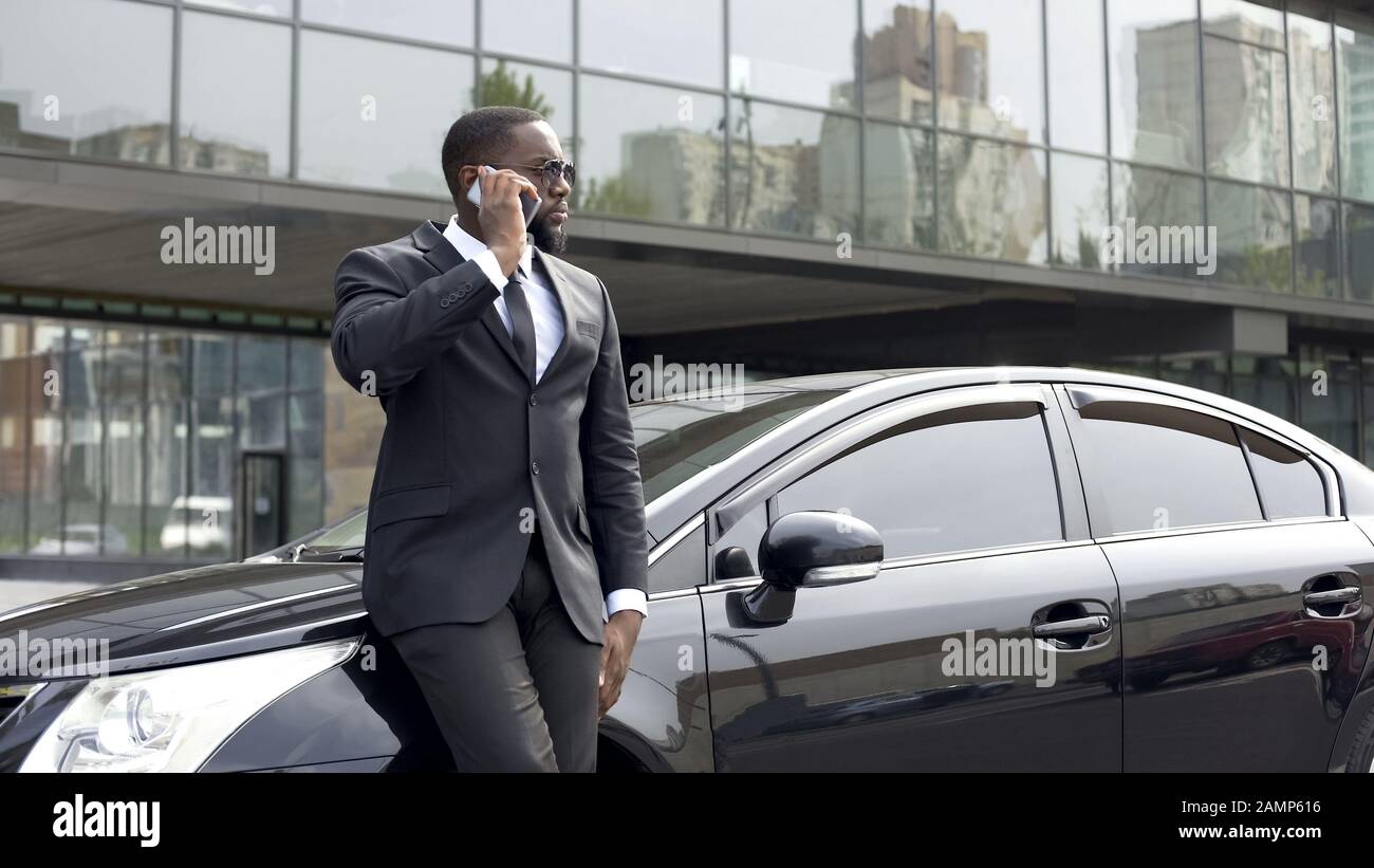 Serious rich man in expensive business suit talking over phone in big ...