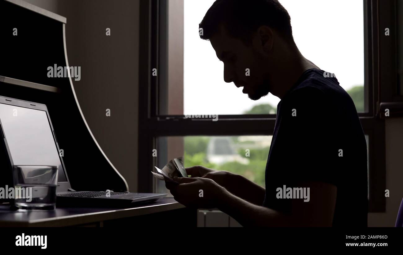 Sad man having financial problems, living on low budget, counting money ...