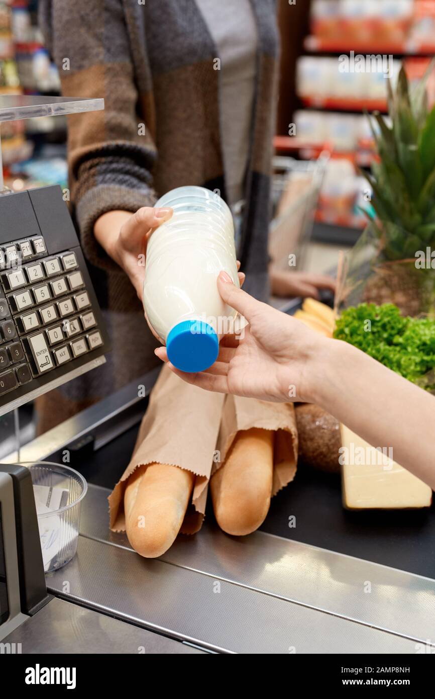 Daily Shopping. Woman standing at checkout counter while cashier ...