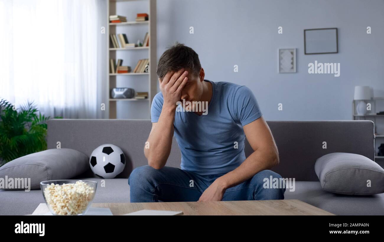 Man upset about defeat of football team, watching tv broadcast, unhappy ...