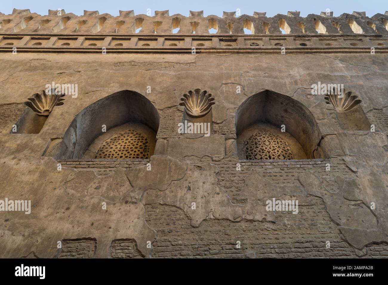 Two perforated arched stucco window decorated with floral patterns, one ...
