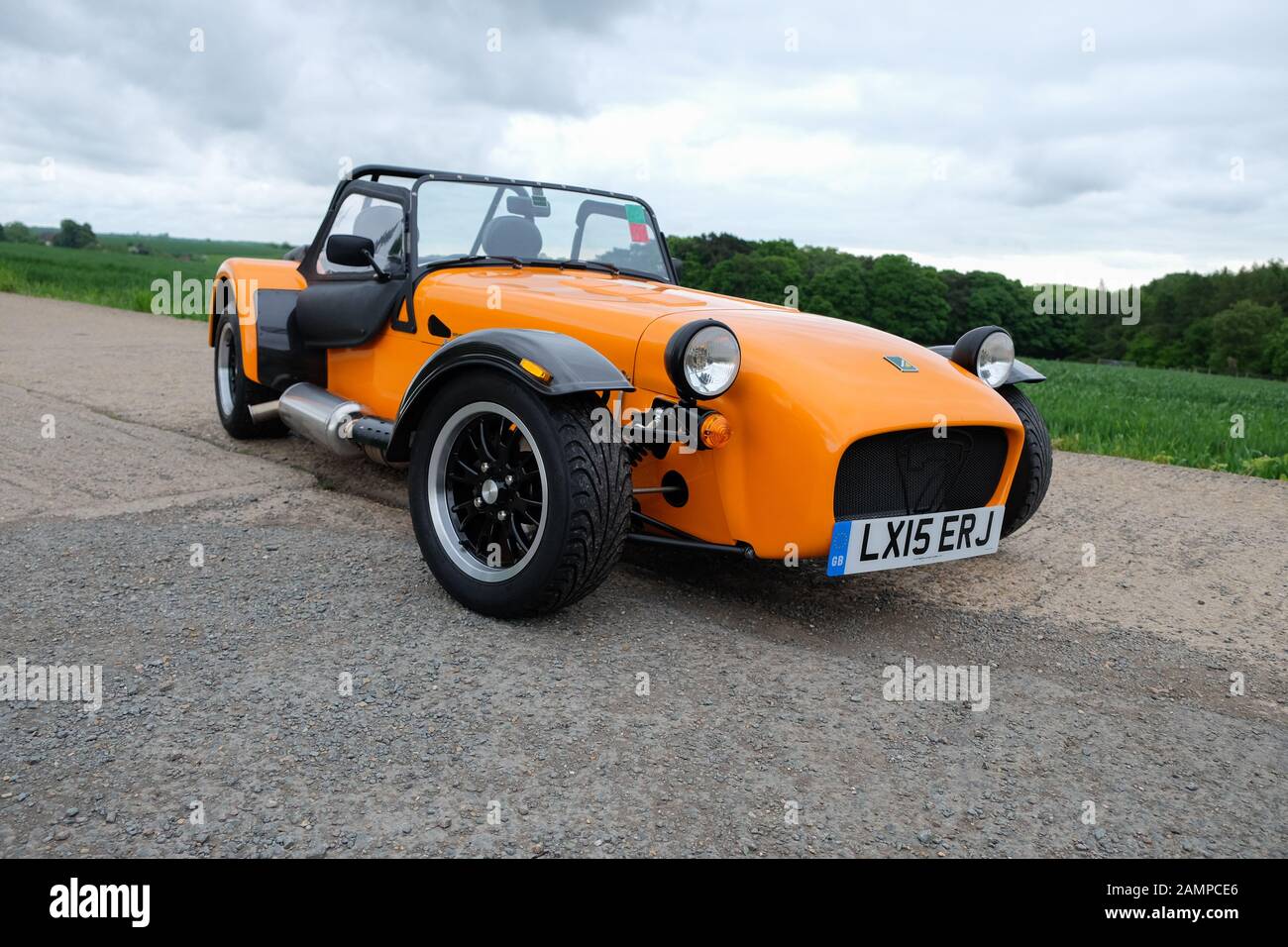 Orange Caterham sports car on old airfield runway Stock Photo - Alamy