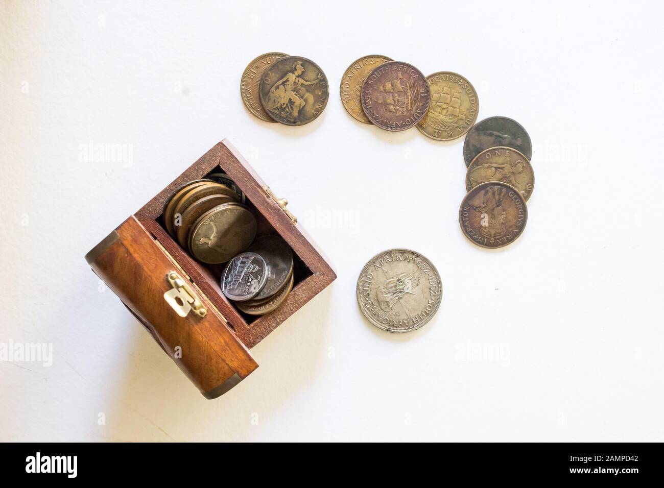 Various old, well-used South African pennies in a small wooden treasure ...