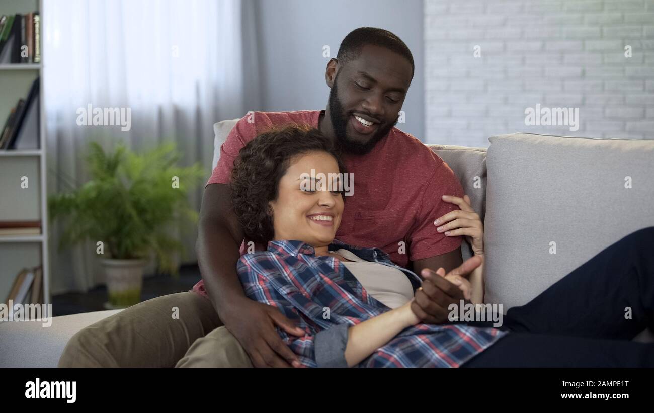 Beautiful multiracial couple having pleasant pastime together at home ...