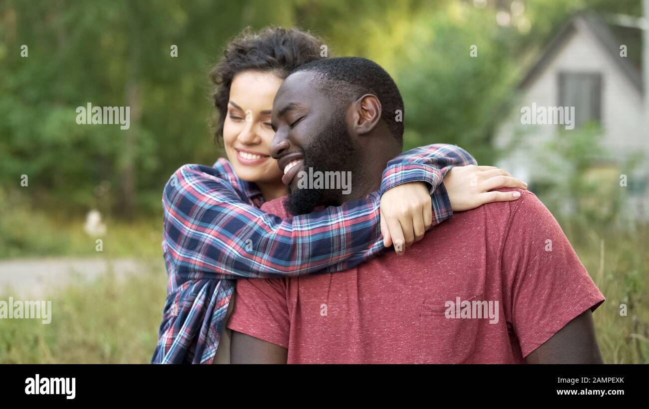 Smiling newly married couple celebrate buying new cottage in ...