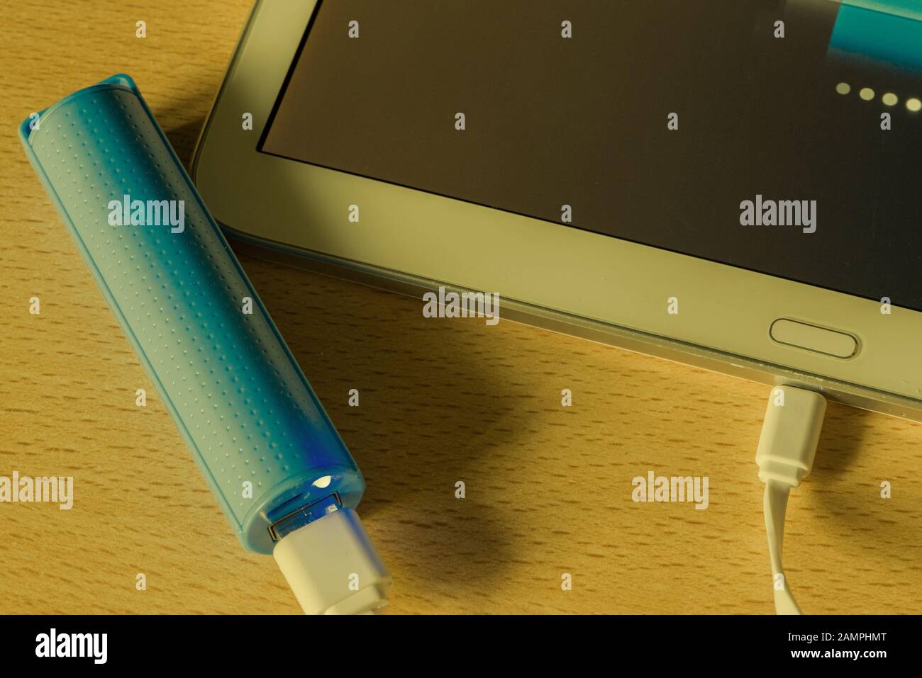 An external battery charging a white tablet Stock Photo - Alamy