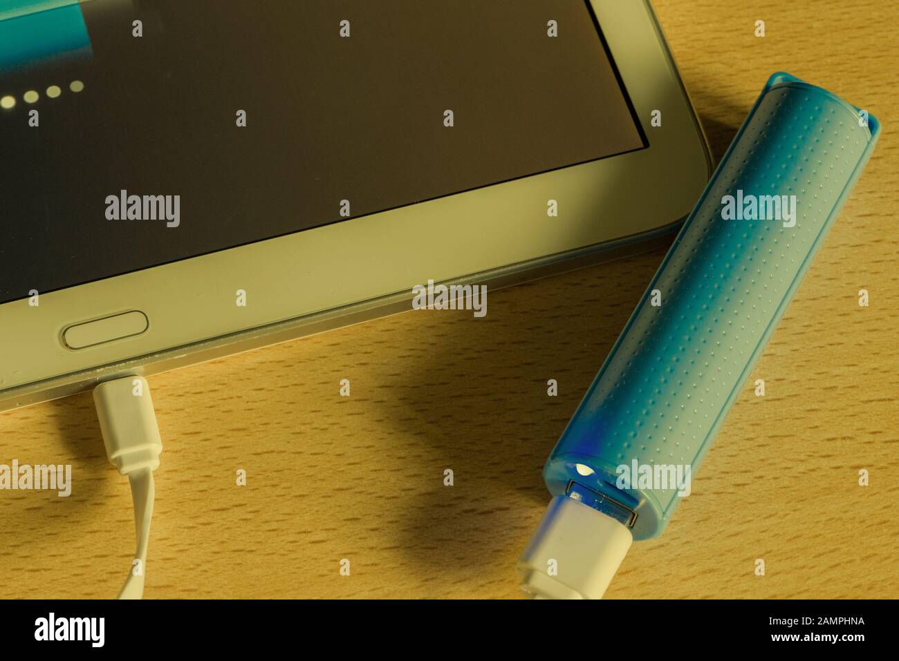 An external battery charging a white tablet Stock Photo - Alamy